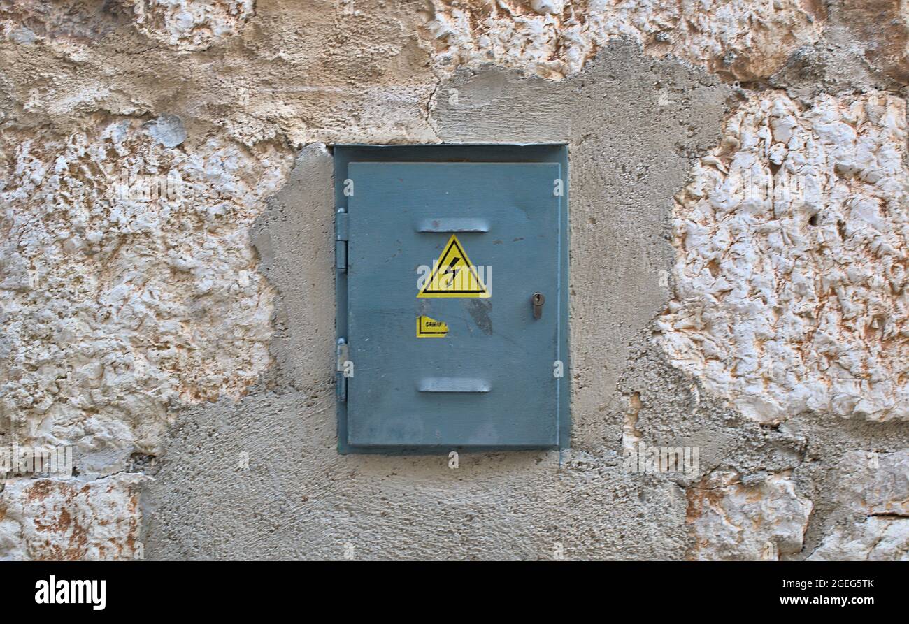 Electrical junction box with a yellow electric shock hazard sign on the ...