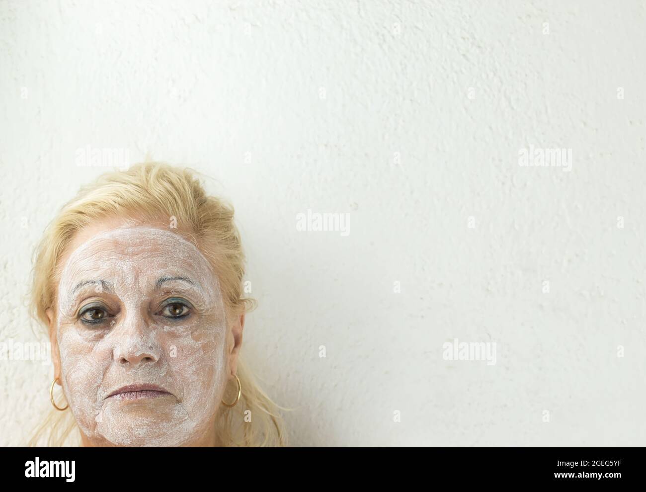 woman posing with beauty mask of cosmetic on her face on white ...