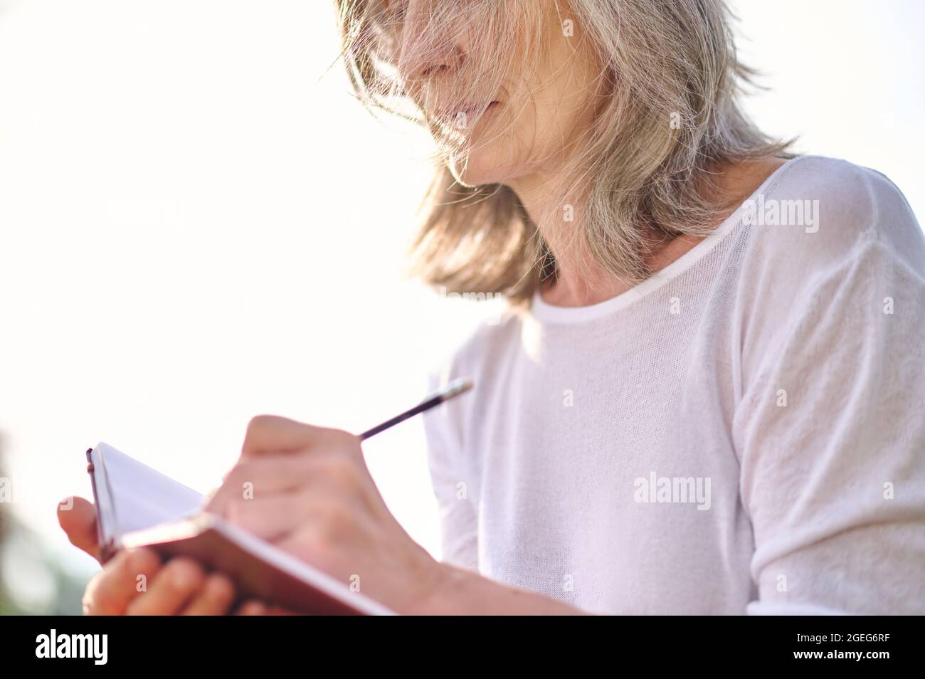 Concerned serious woman taking notes outdoors Stock Photo - Alamy