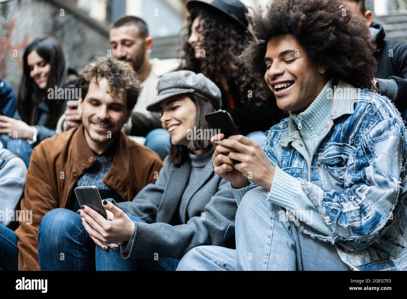 Happy diverse people using mobile phones outdoor in the city - Focus on ...
