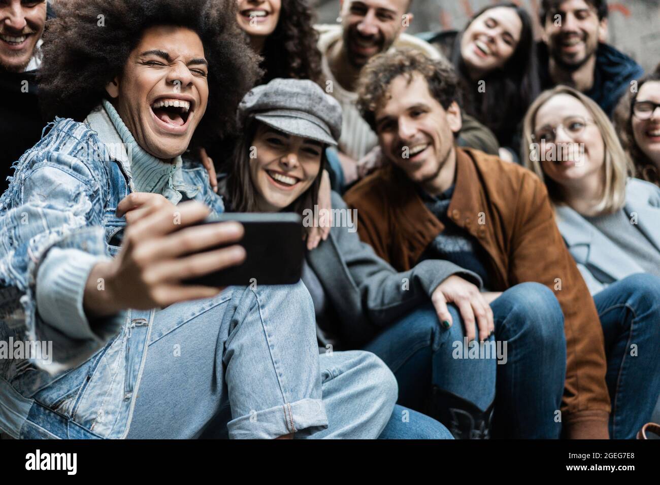 Young diverse people using mobile phones outdoor in the city - Main ...