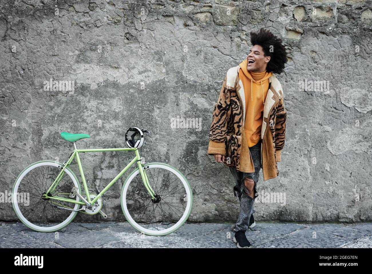 Young african boy having fun with his bicycle outdoor in the city ...