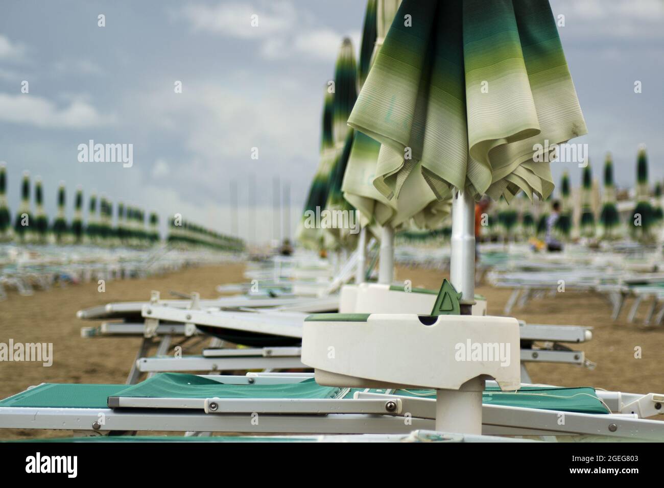 Closeup shot of closed parasols and lounge chairs on the Stock Photo ...