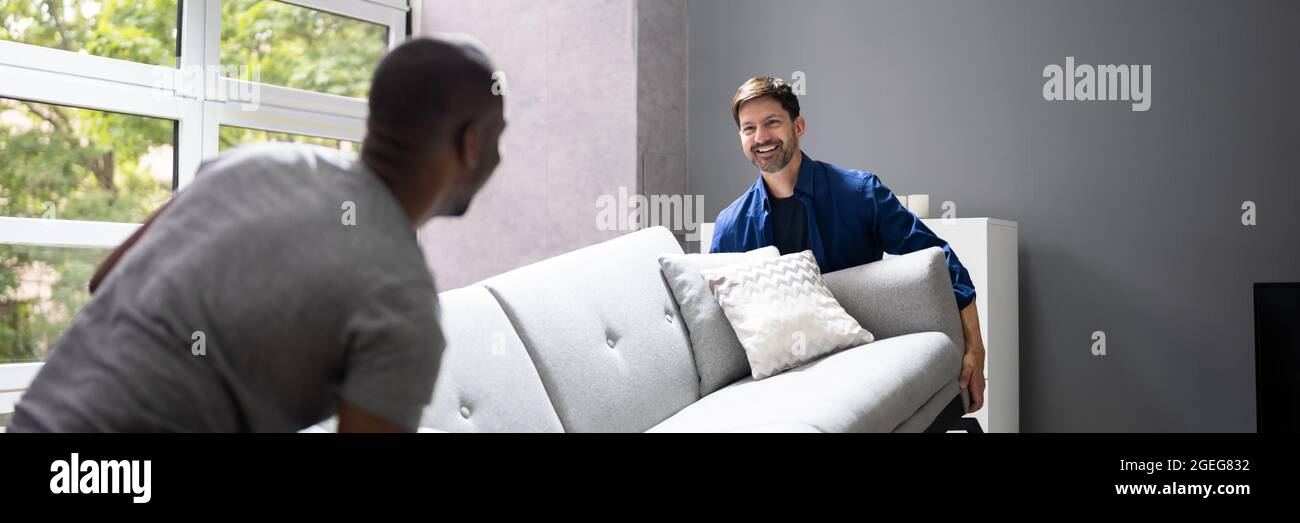 Couple Moving Furniture In Living Room. Carrying Sofa Stock Photo - Alamy