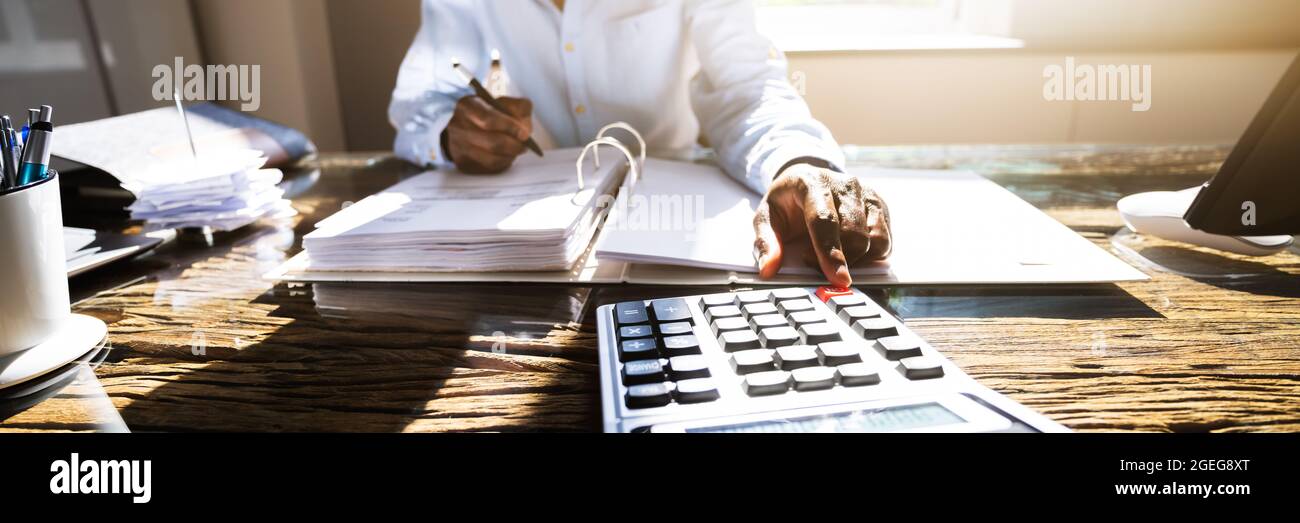 African American Male Accountant Using Calculator For Accounting Stock ...
