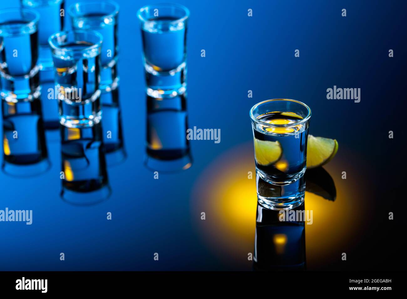 Vodka with a lime slice on a black reflective background. Strong ...