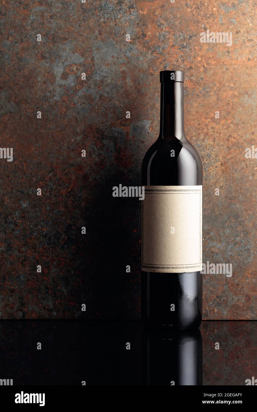 Bottle of red wine with old empty label on rusty brown background ...
