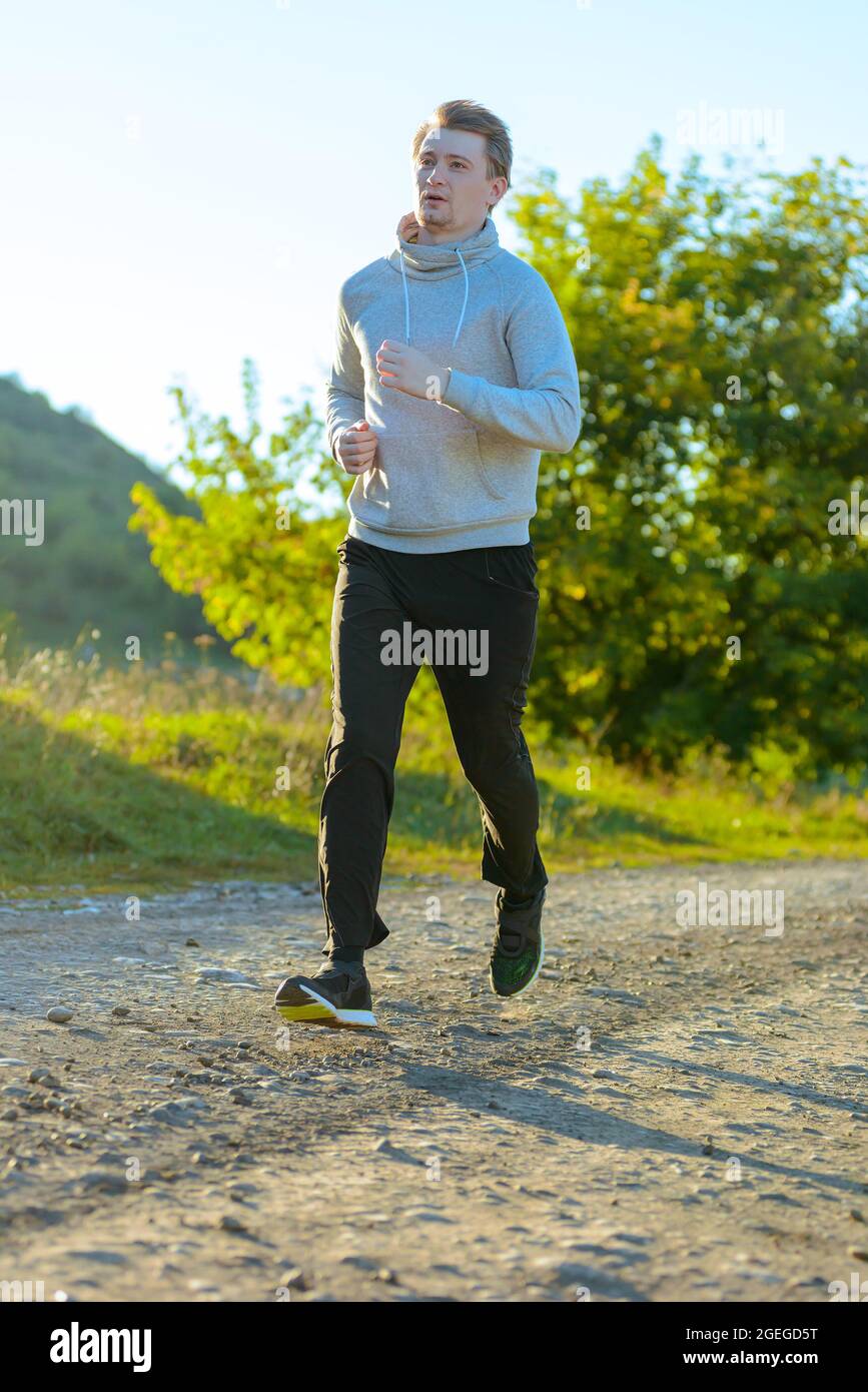 Running man jogging in rural nature at beautiful summer day. Sport ...