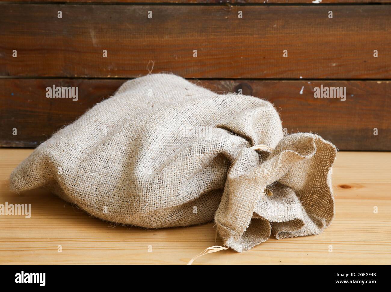a tied linen sack in front of a wooden backdrop Stock Photo - Alamy