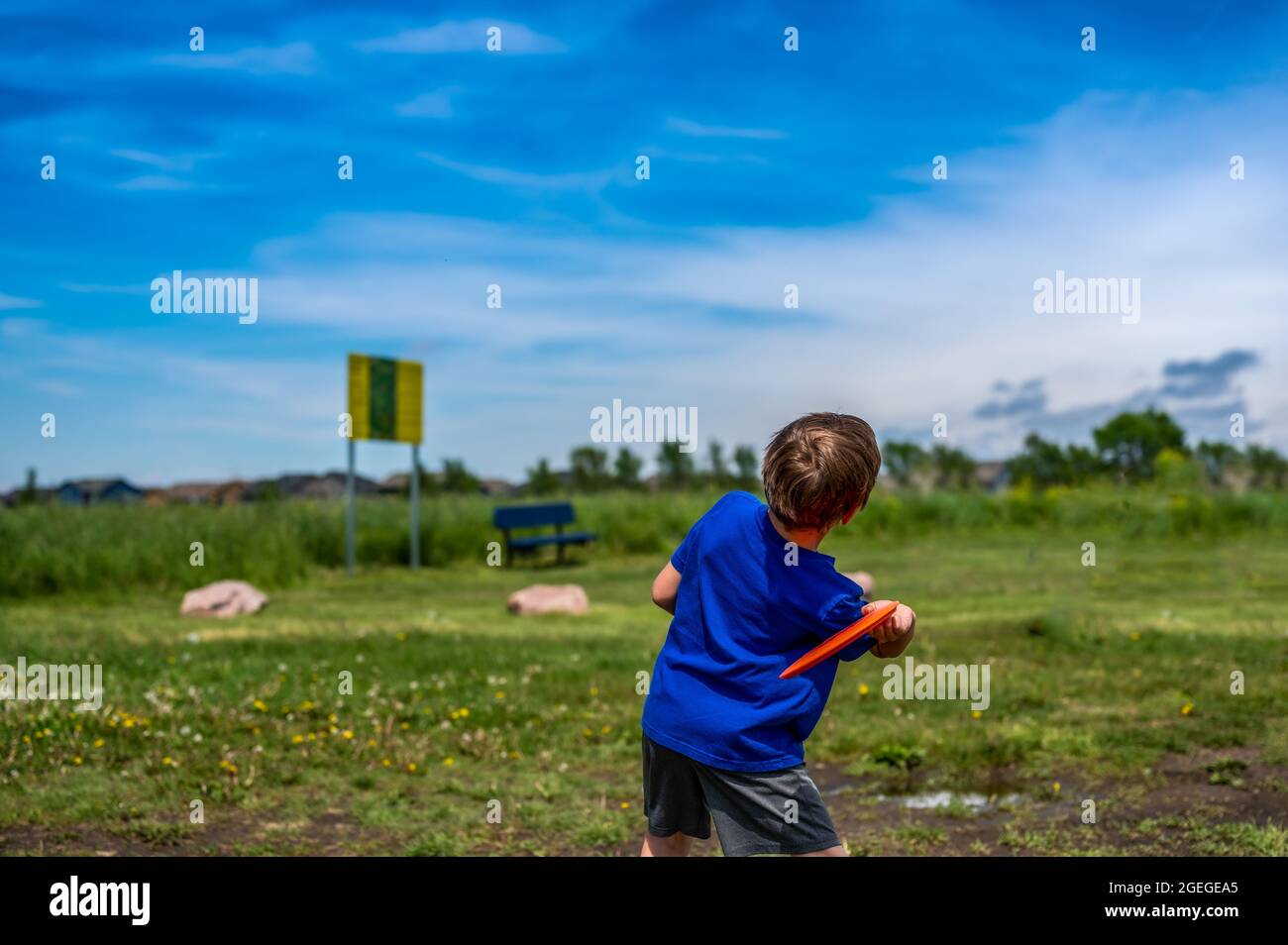 Caucasian child playing disc golf and making the first toss Stock Photo ...