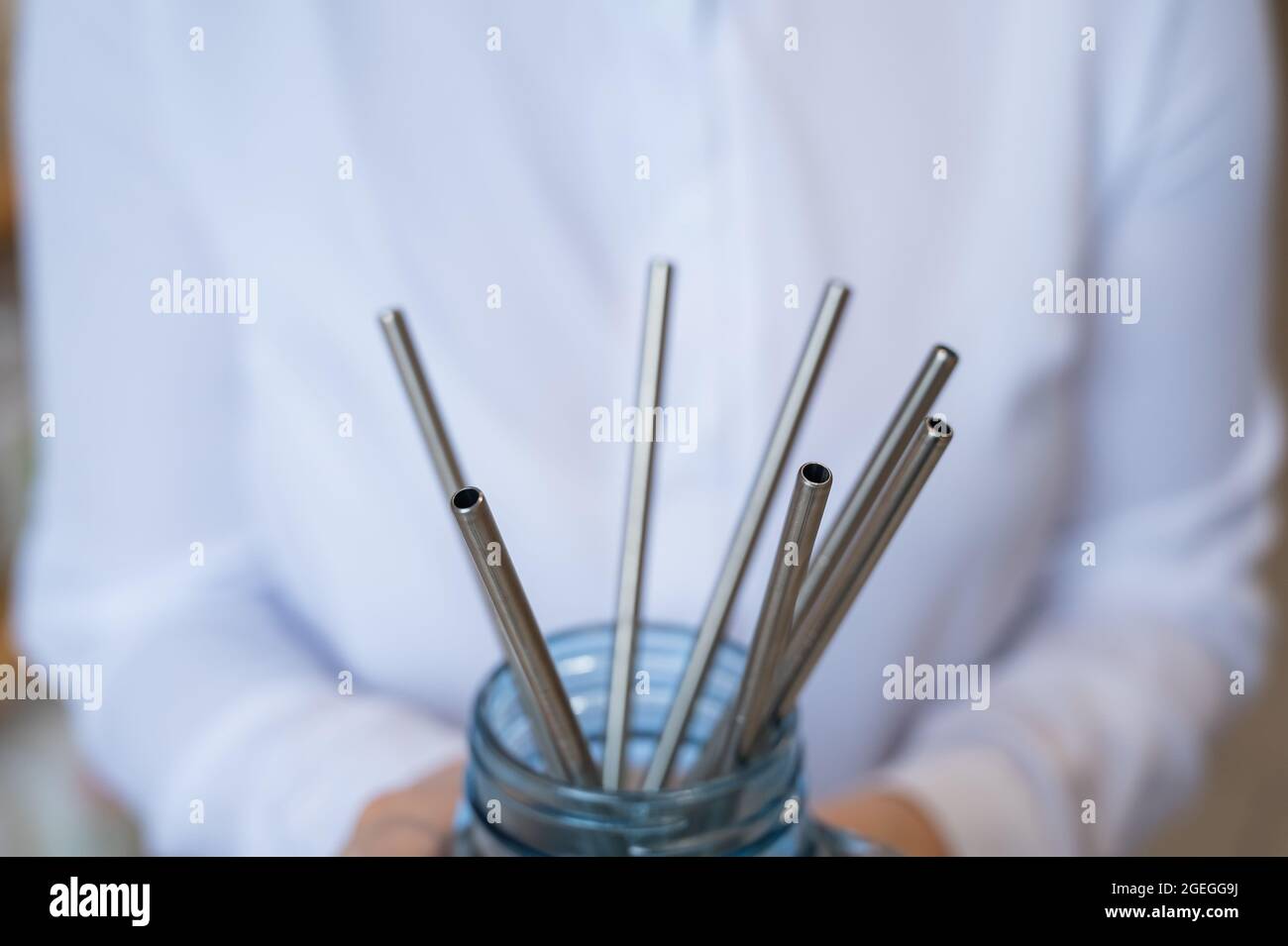 A woman holds a jar of reusable steel tubes. Eco concept Stock Photo ...