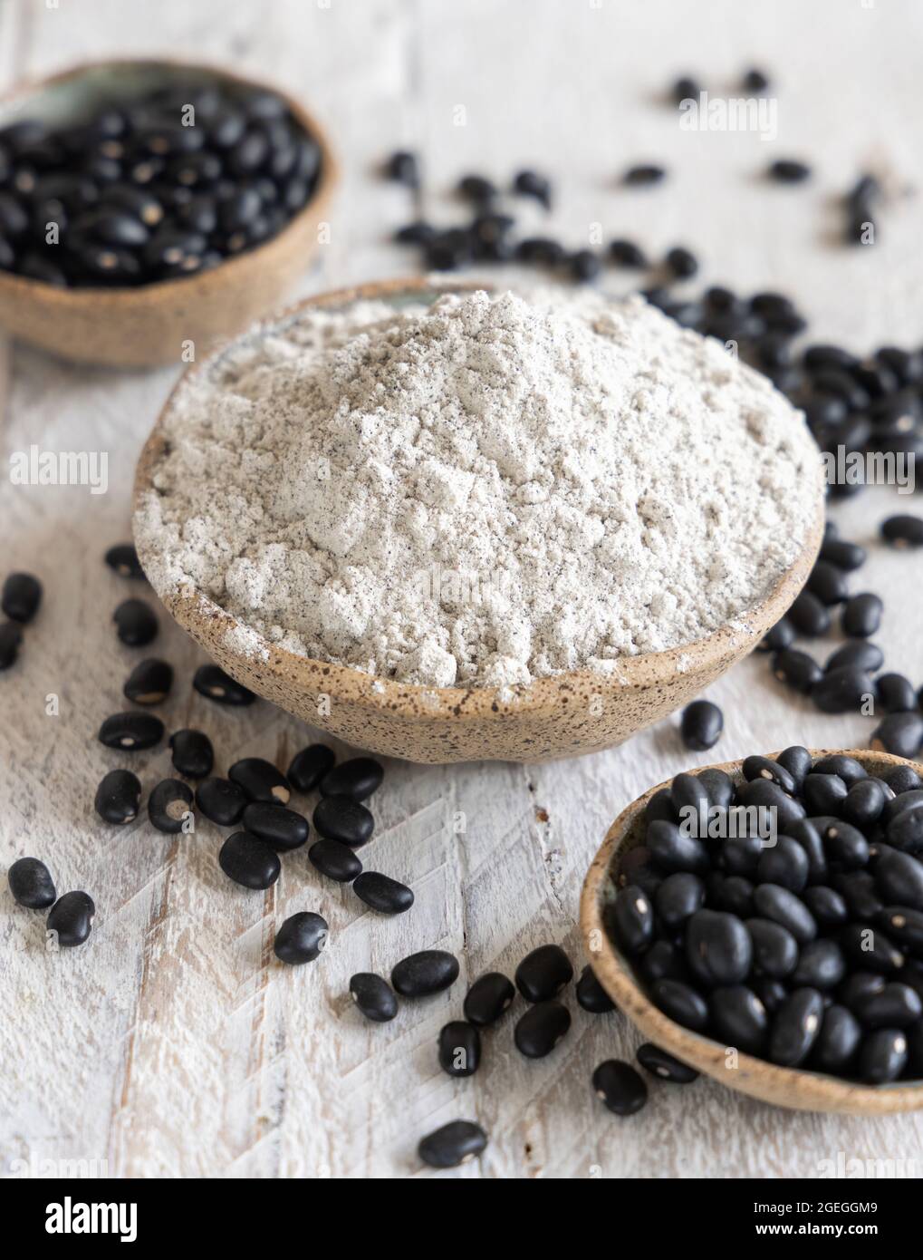 Ceramic bowls with black beans flour and dried beans closeup. Healthy ...