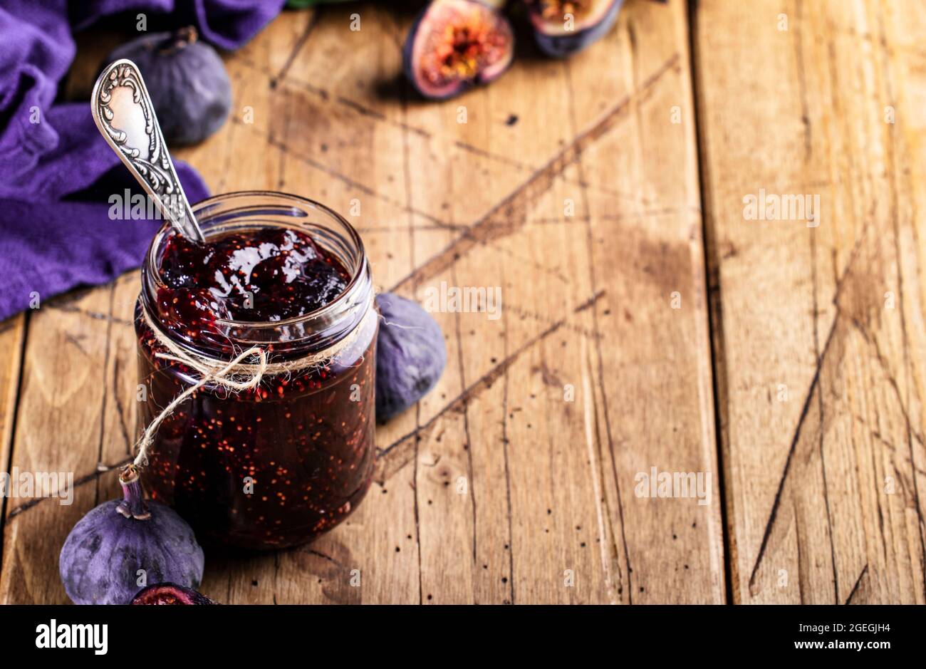 Fig confiture in glass jar. Fresh fruits on wooden kitchen table ...