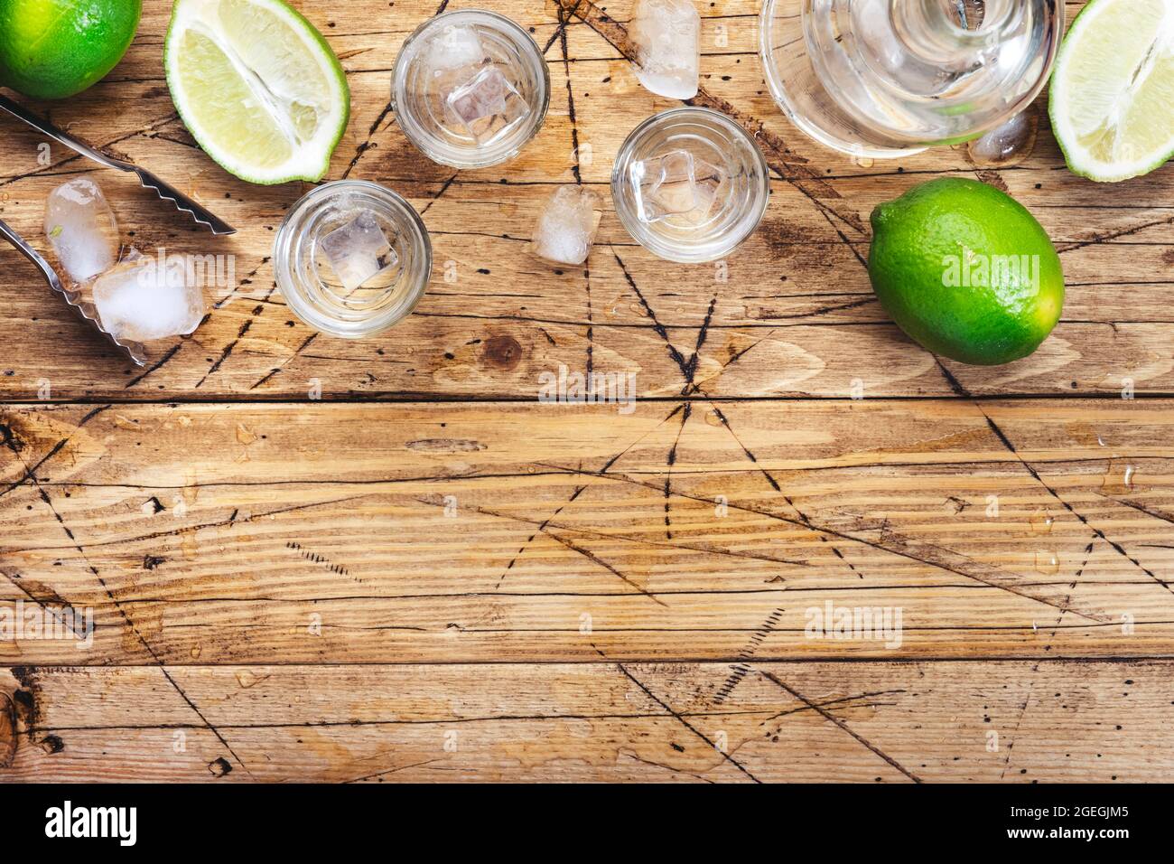 Brazilian vodka cachaca in shot glasses with lime on wooden table, iced ...