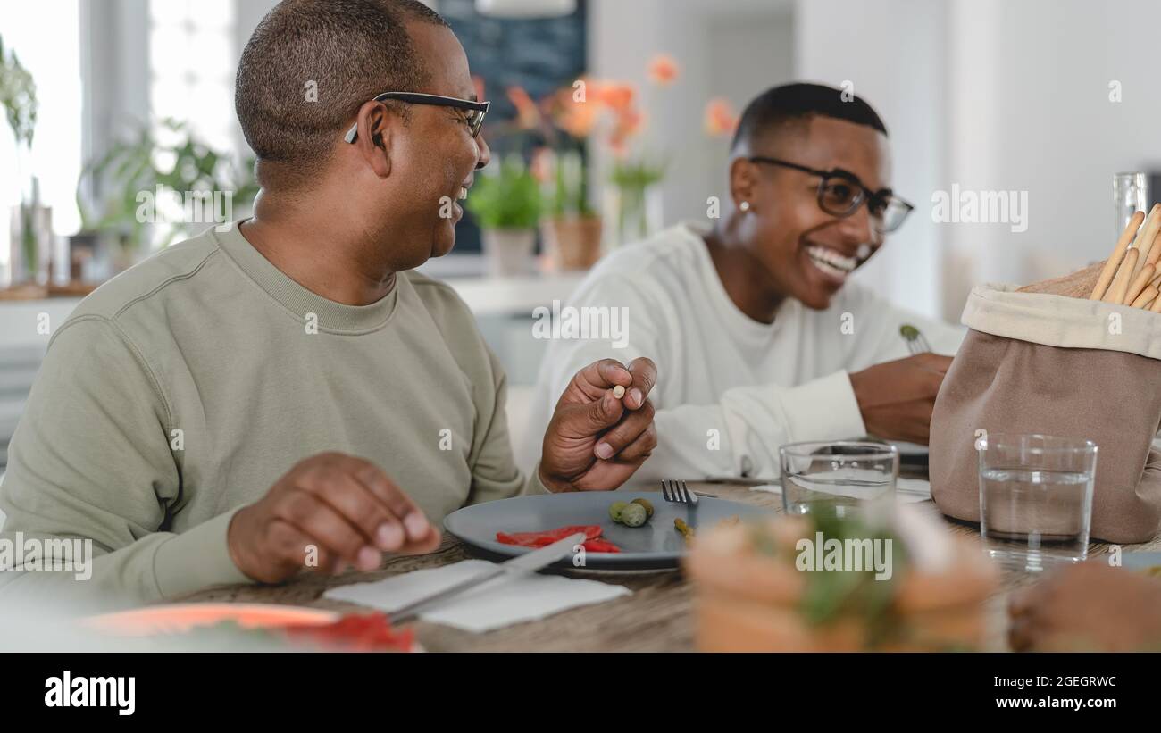 Happy Hispanic family having fun eating healthy lunch together at home ...