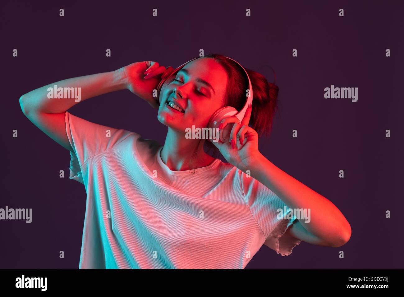 Portrait of pretty romantic girl on dark purple studio background in ...