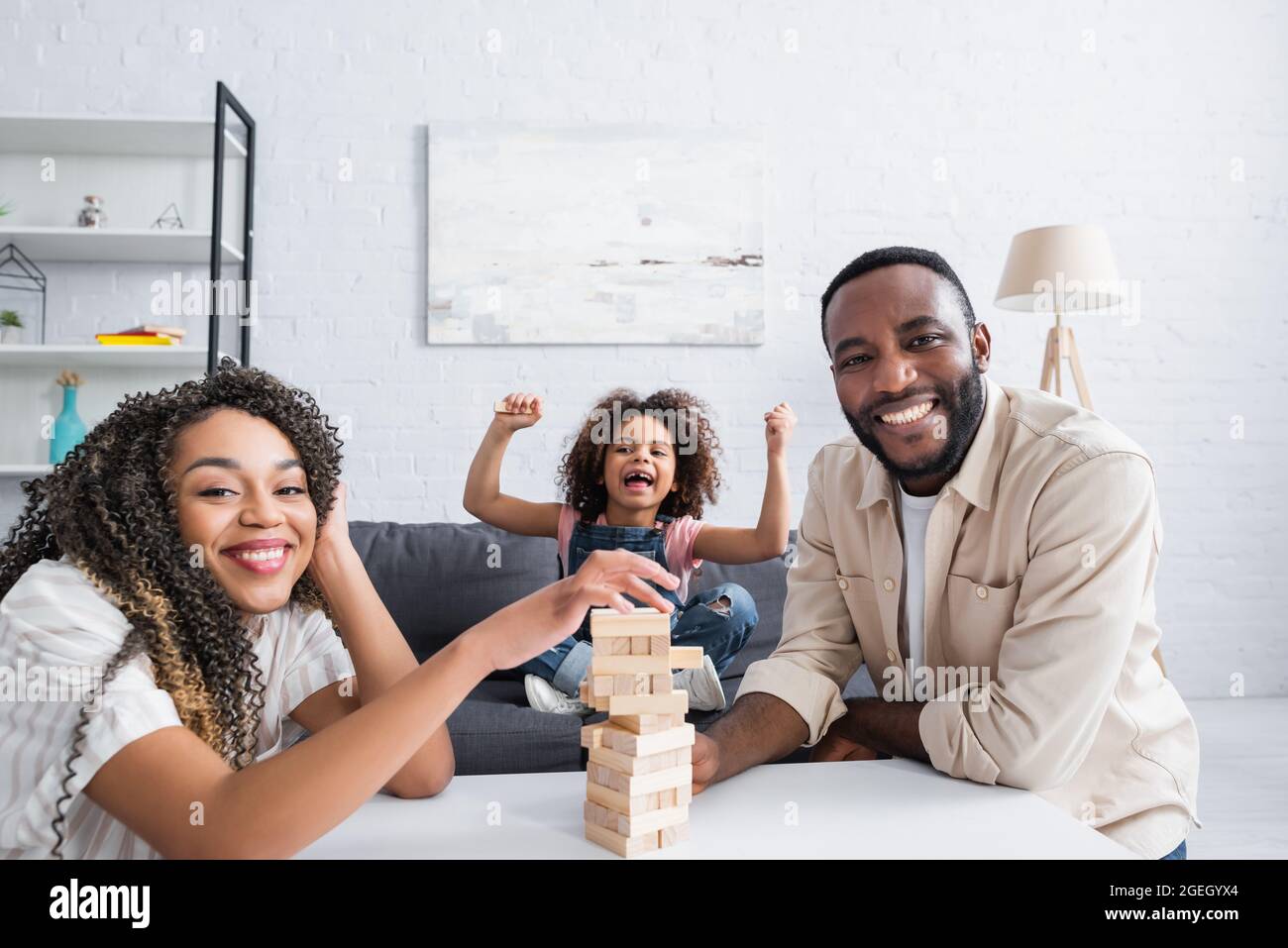 excited african american girl showing triumph gesture near smiling ...