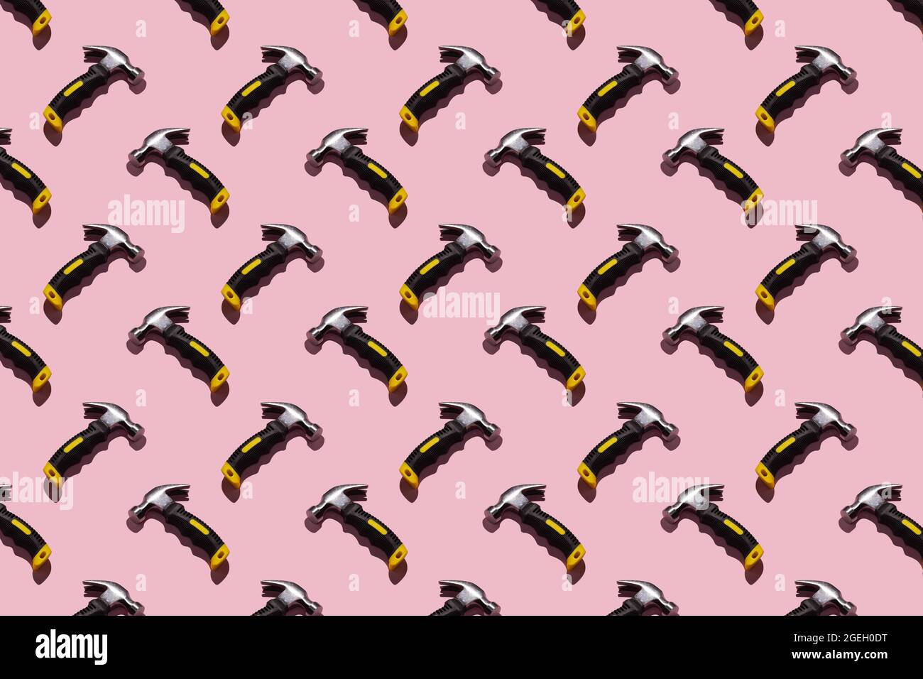 Hammers on pink background, pattern, hard shadows. Construction tools ...