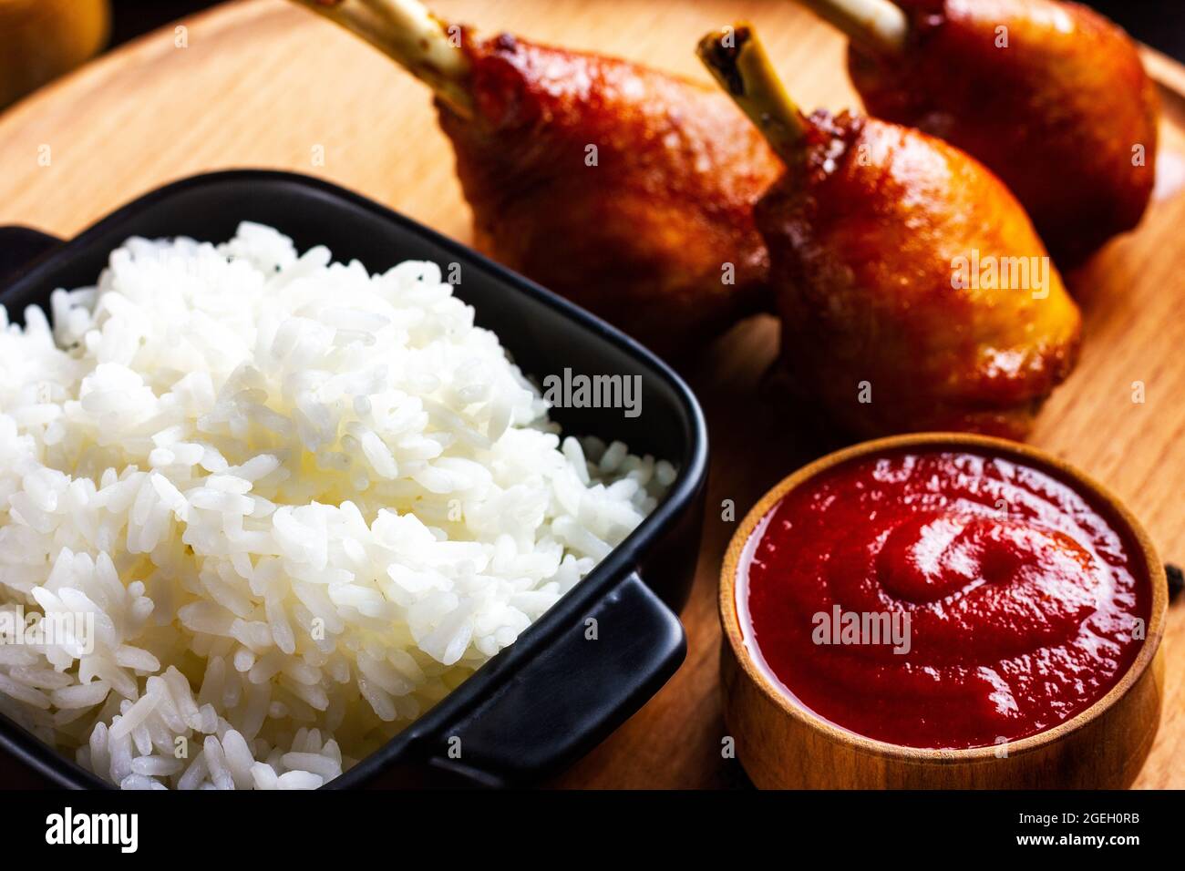 Rice with ketchup and baked chicken legs Stock Photo - Alamy