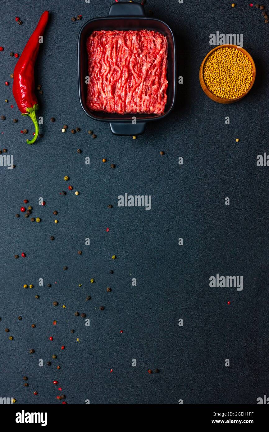 Culinary frame background in dark shades with minced meat, pepper ...