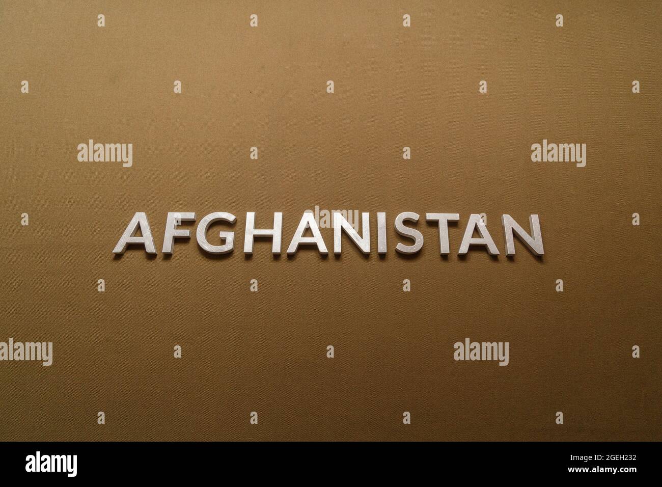 the word afghanistan laid with silver metal letters on rough flat tan ...