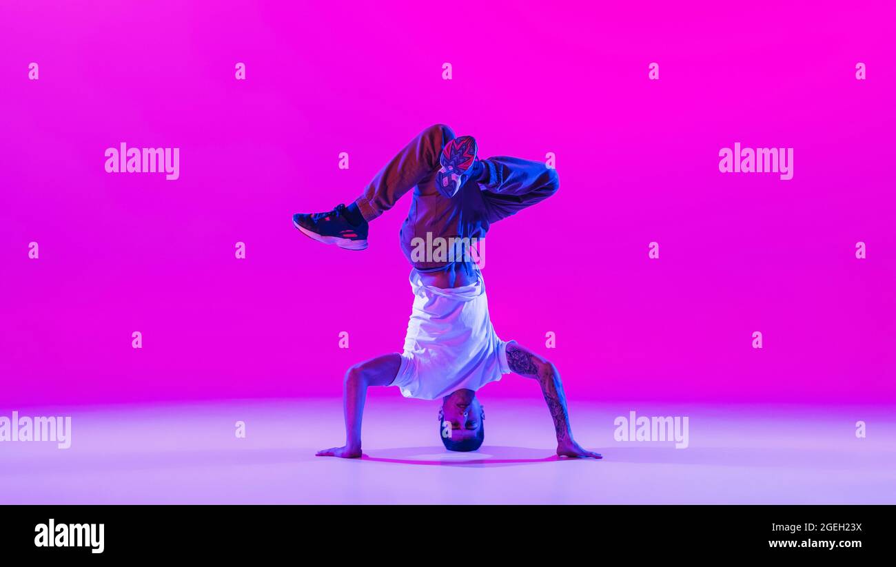 One young stylish man, break dancing dancer training in modern clothes ...