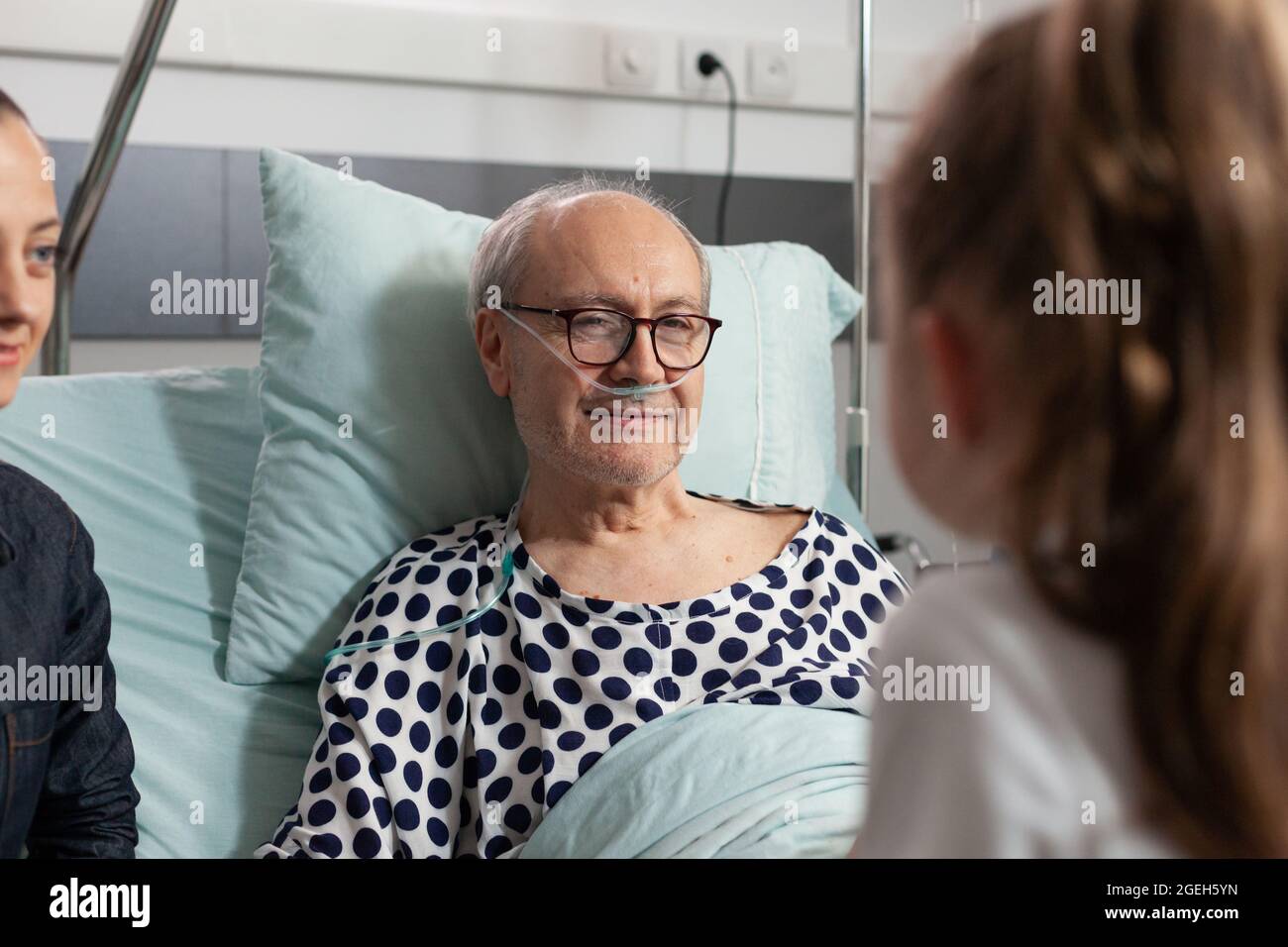 Selectiv focus of elderly sick old man resting in bed talking with ...