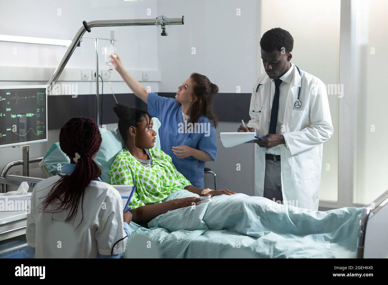 Multi ethnic staff working on young adult healthcare in hospital ward ...