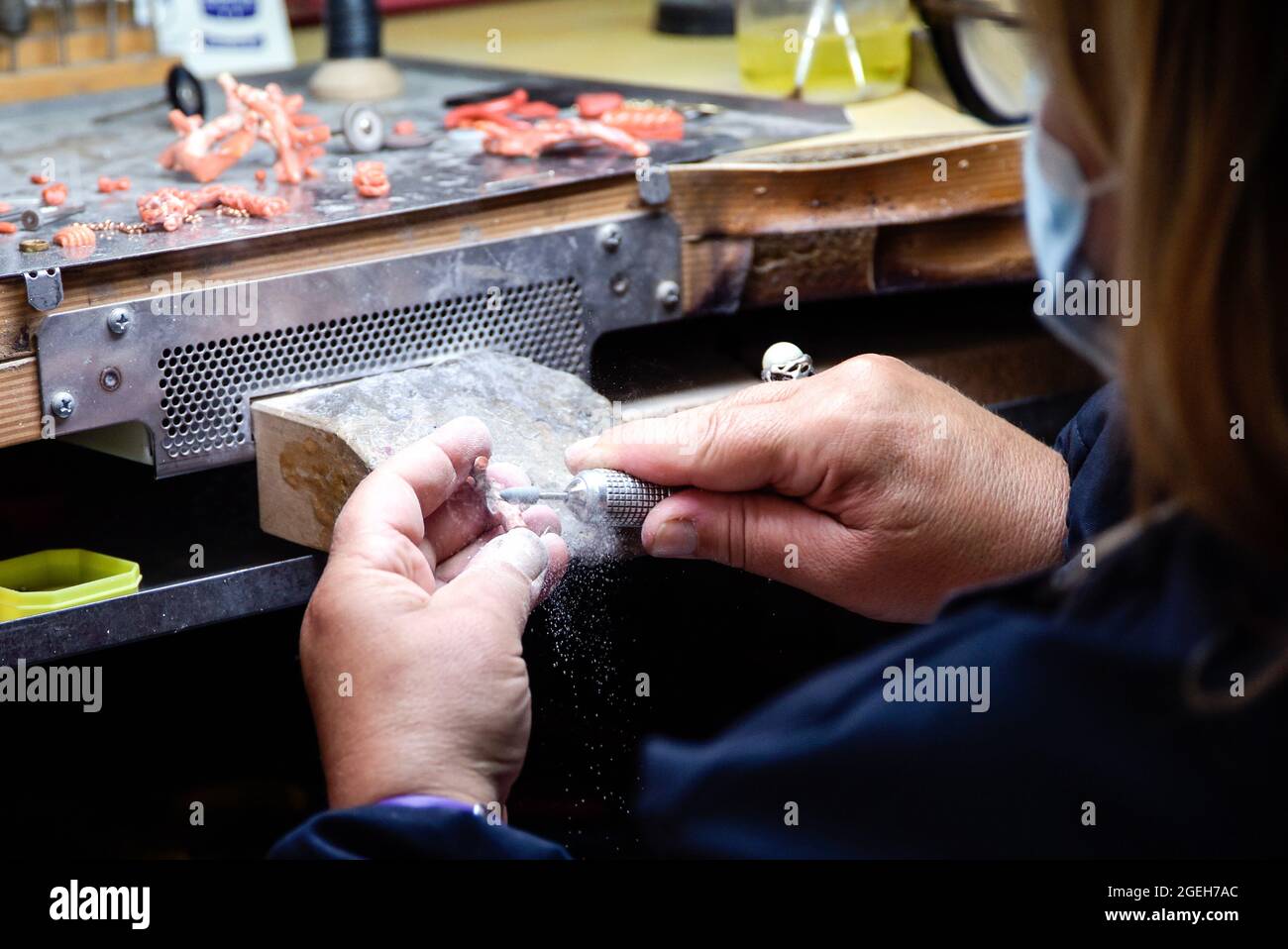 A woman learns coral processing techniques inside a laboratory in ...