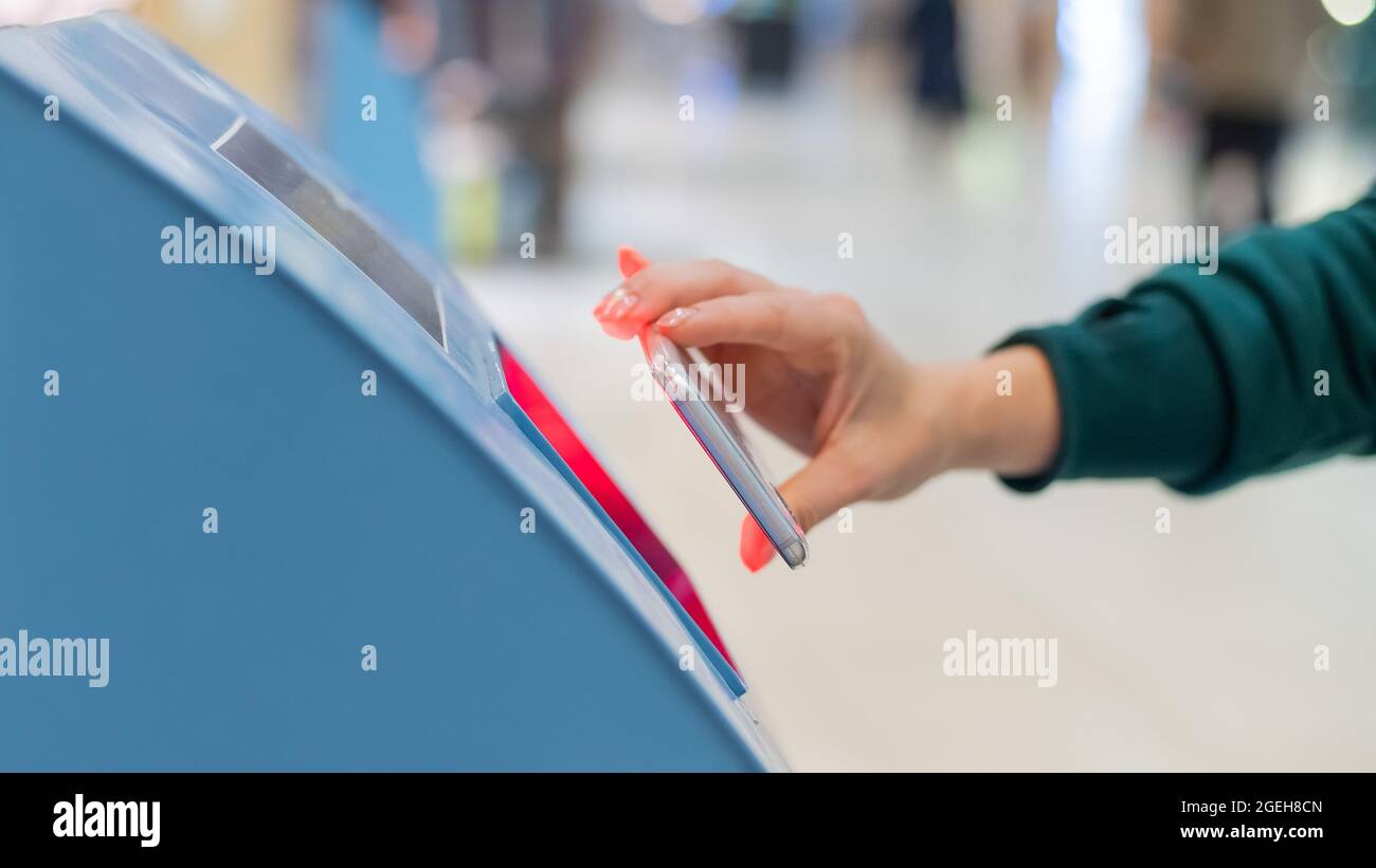A faceless woman scans the qr code from her smartphone. A girl uses a ...