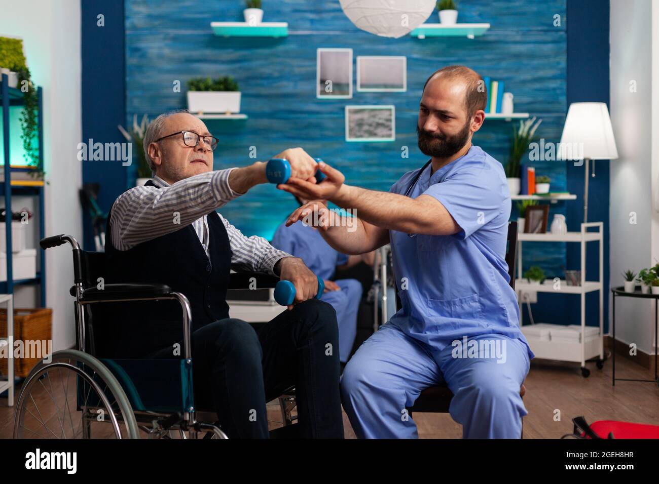 Practitioner man doctor helping retiree senior male in wheelchair to do ...
