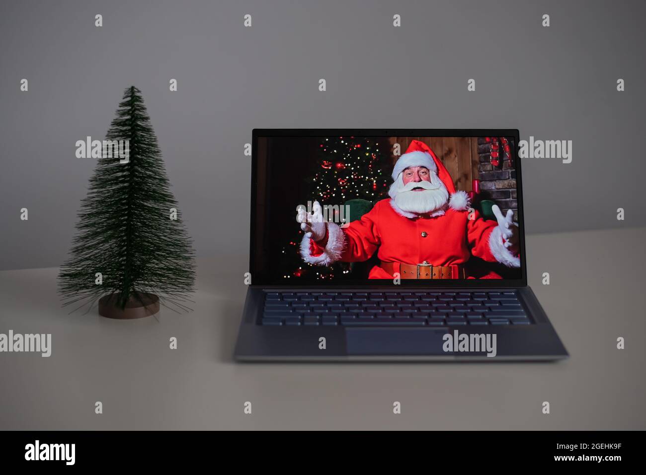 Santa Claus wishes Merry Christmas by video call on a laptop. Remote ...