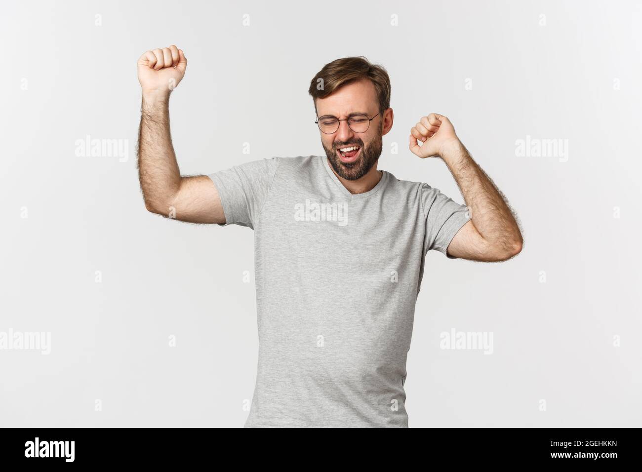 Image of excited man in gray t-shirt and glasses, winning something ...