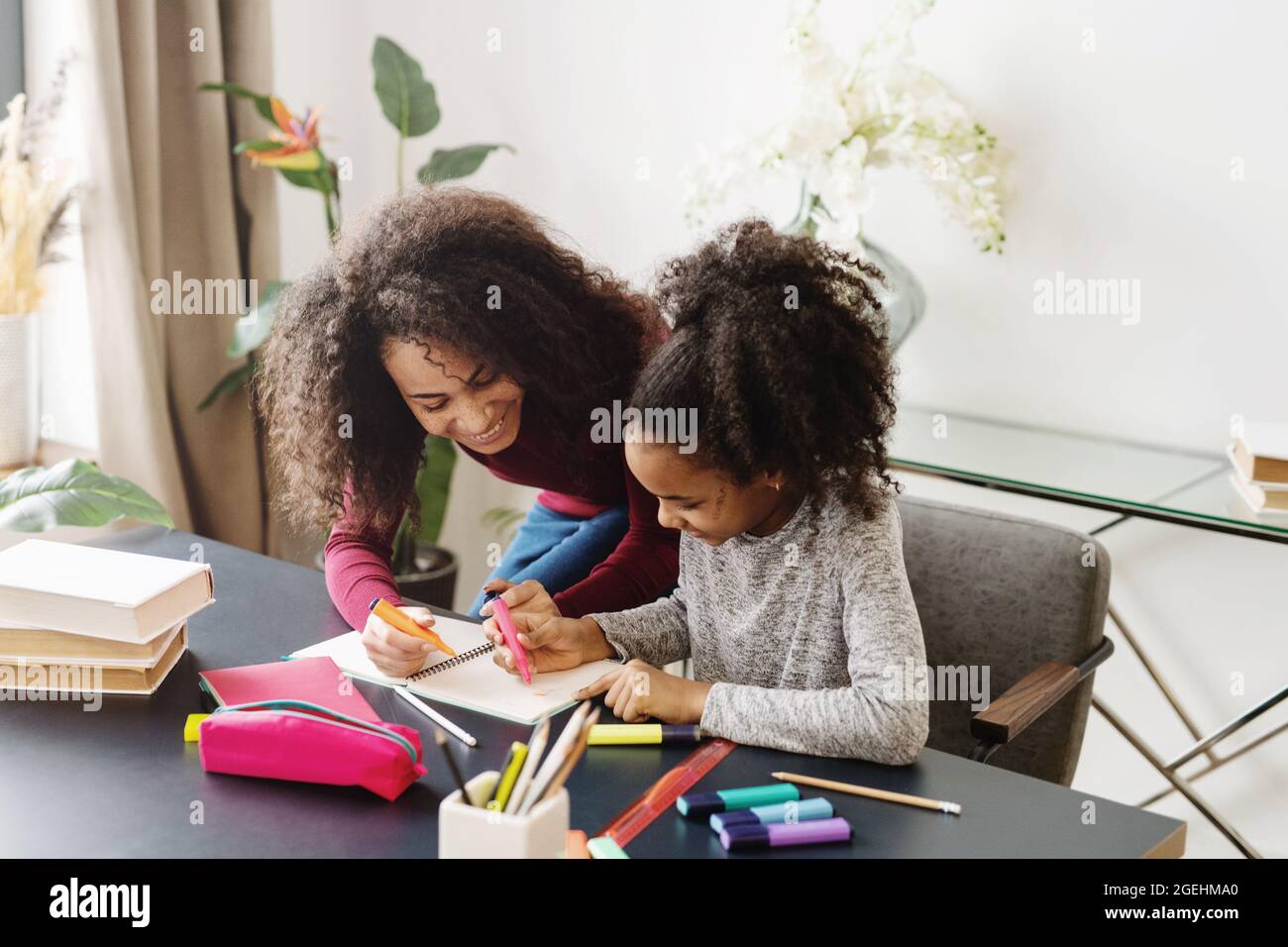 Mother helping daughter with homework Stock Photo - Alamy