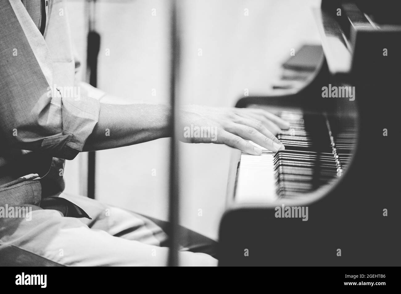 Grayscale shot of a male in an elegant suit playing piano Stock Photo ...