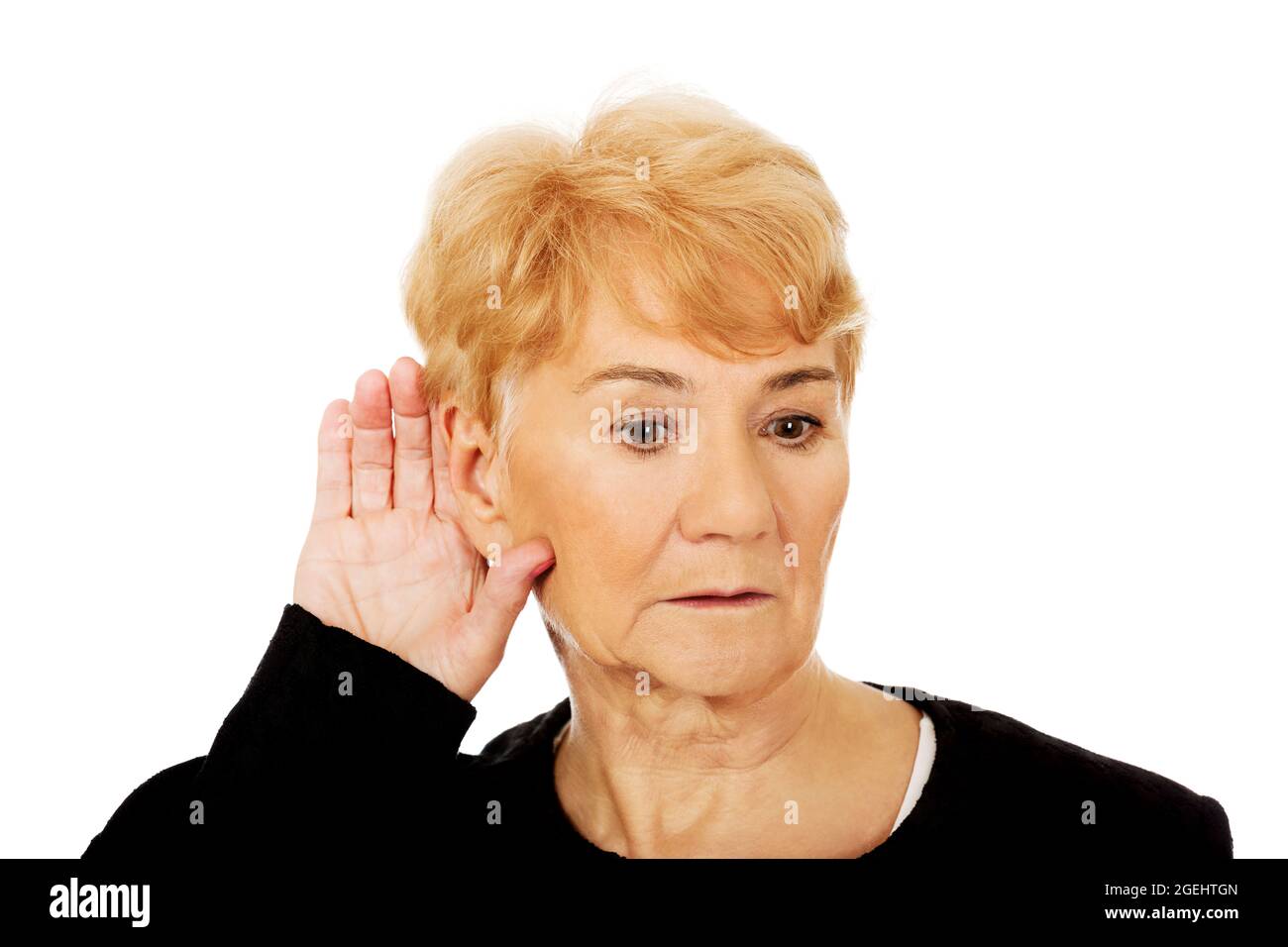 Senior woman trying to hear with her hand close to her ear Stock Photo ...
