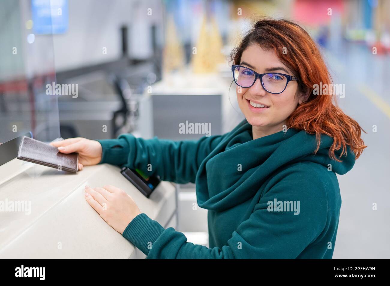 A woman at the check-in counter at the airport and gives her passport ...
