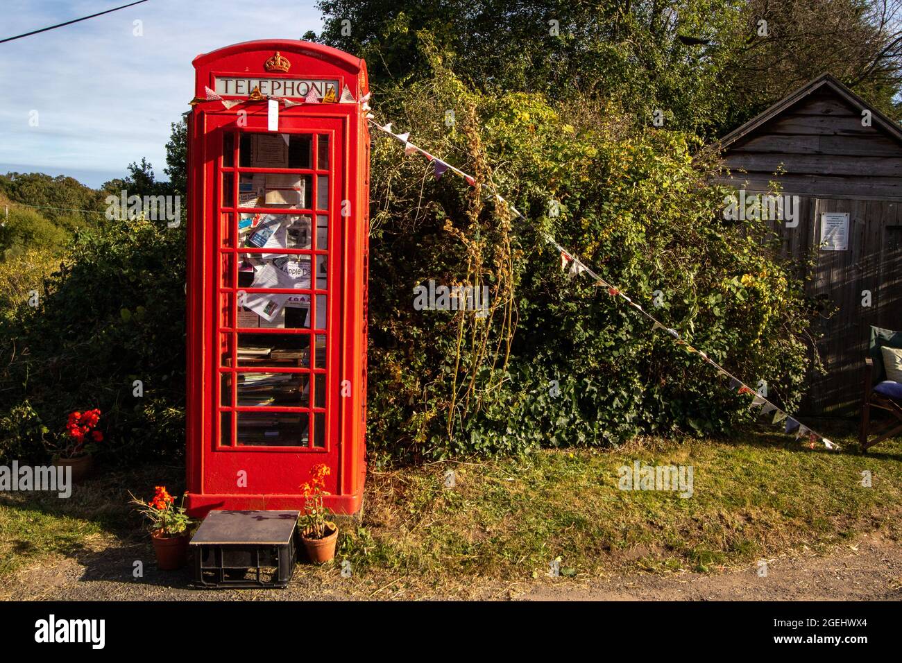 A traditional red telephone box in a Suffolk village put to a new use ...