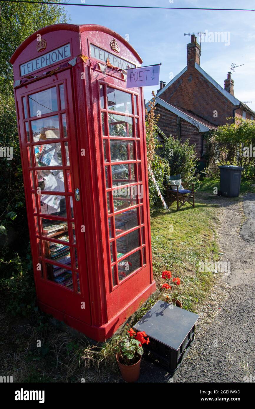 A traditional red telephone box in a Suffolk village put to a new use ...