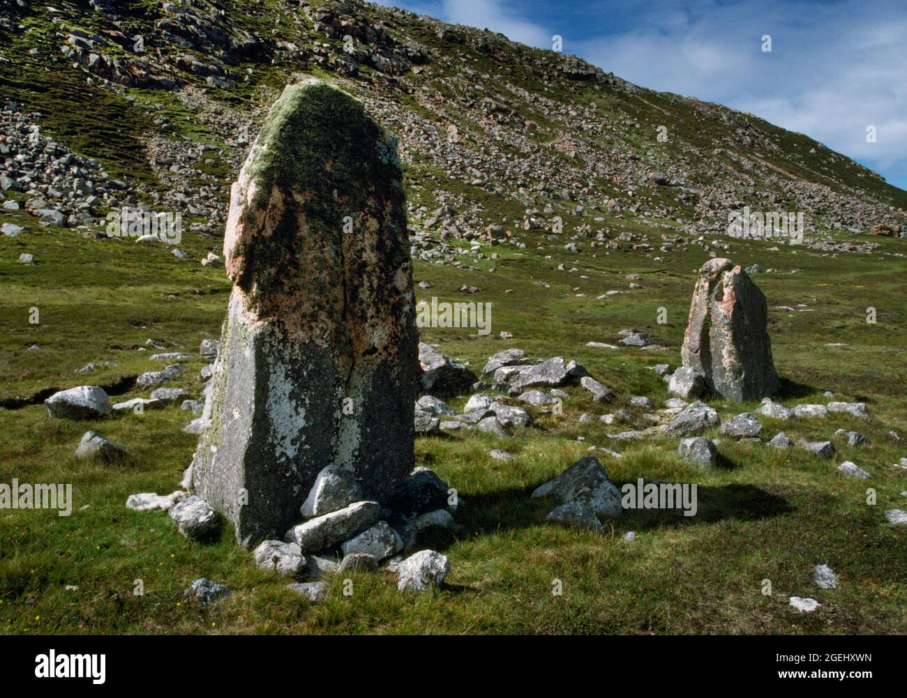 View NE of two standing stones flanking a ruined cairn below the rocky ...