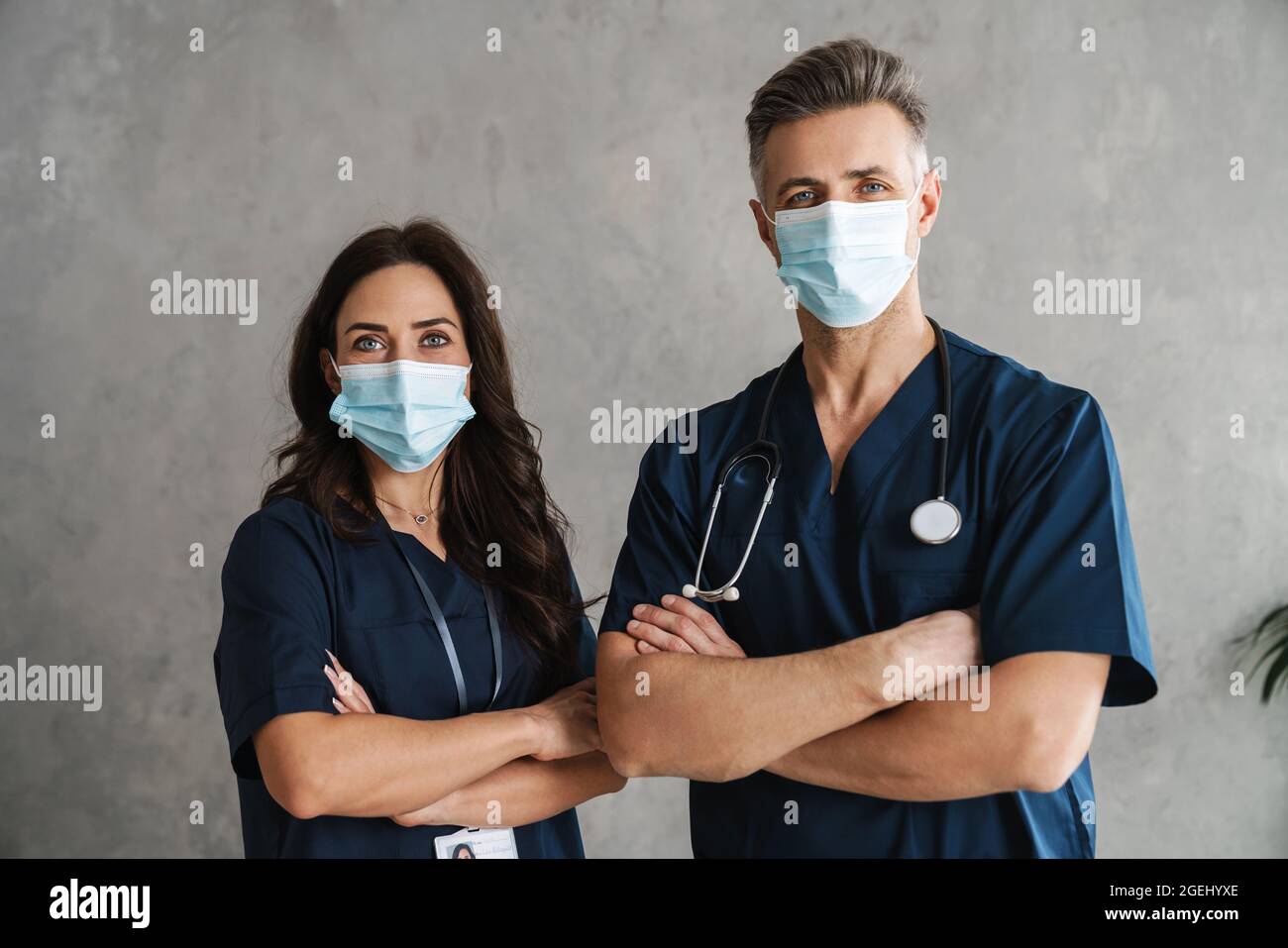 Two confident doctors in medical masks standing indoors Stock Photo - Alamy