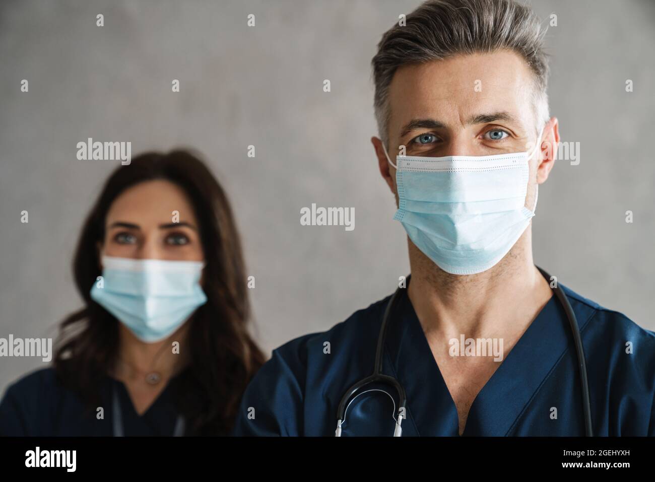 Two confident doctors in medical masks standing indoors Stock Photo - Alamy