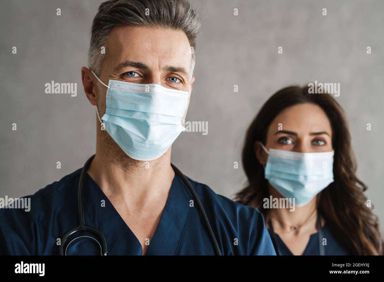 Two confident doctors in medical masks standing indoors Stock Photo - Alamy
