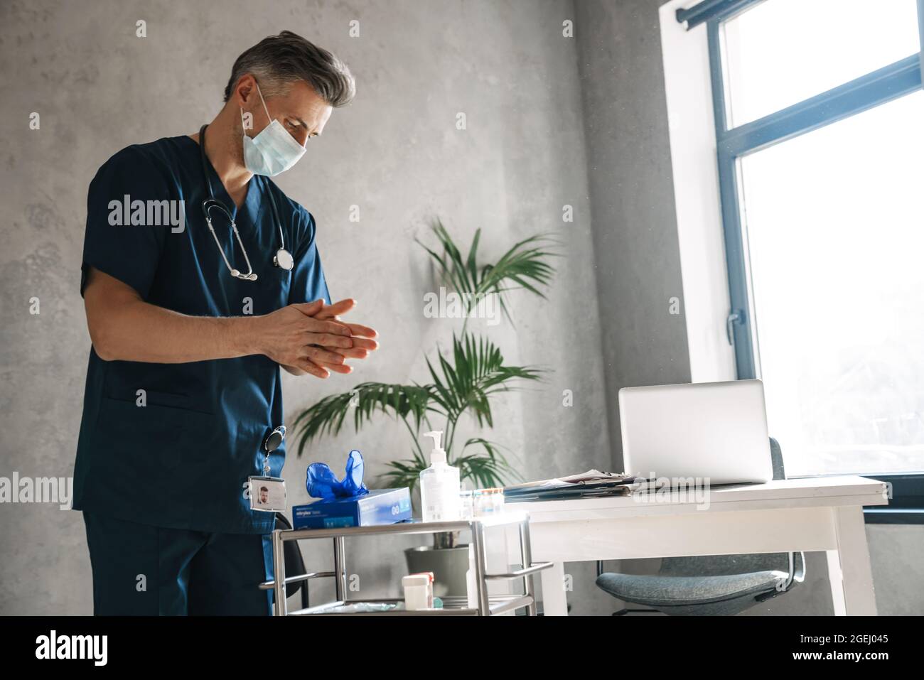 Doctor sanitizing hands hi-res stock photography and images - Alamy