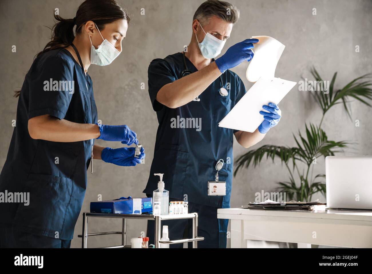 Two doctors getting ready to have patients in cabinet, looking through ...
