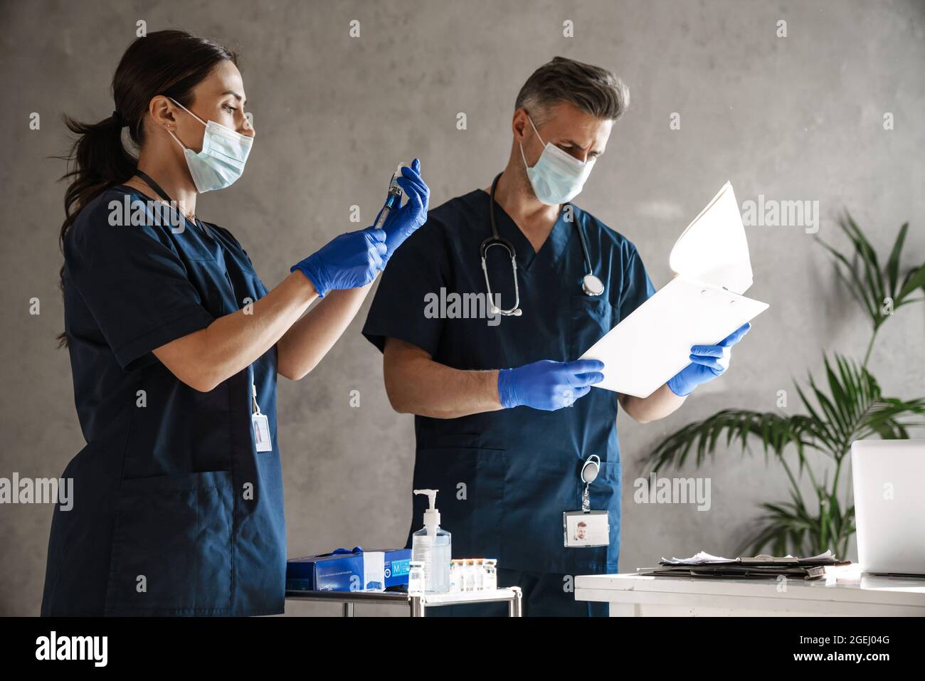 Two doctors getting ready to have patients in cabinet, looking through ...