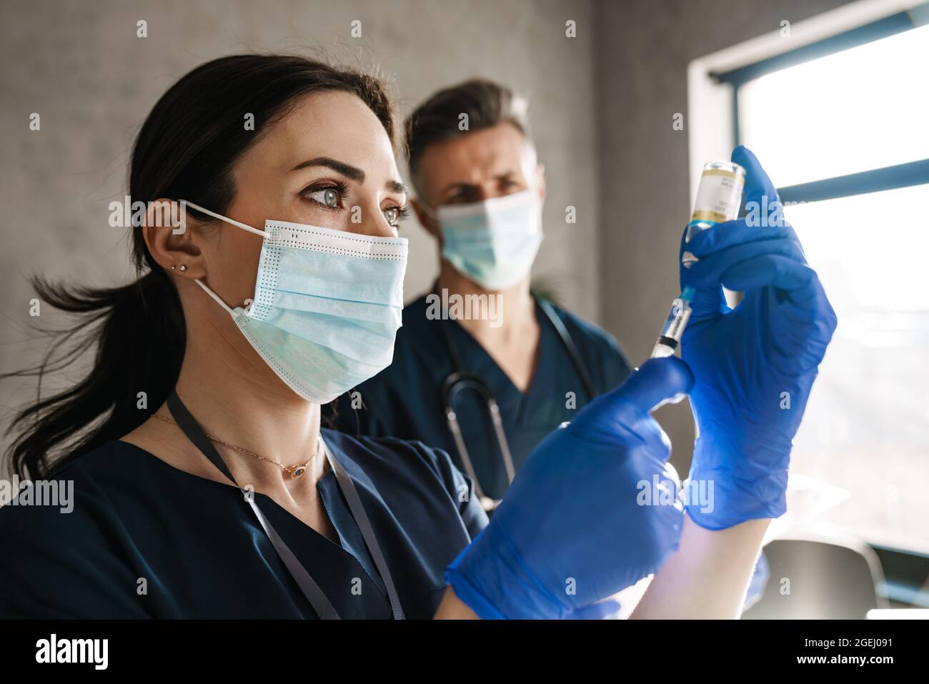 Two doctors getting ready to have patients in cabinet, holding syringe ...