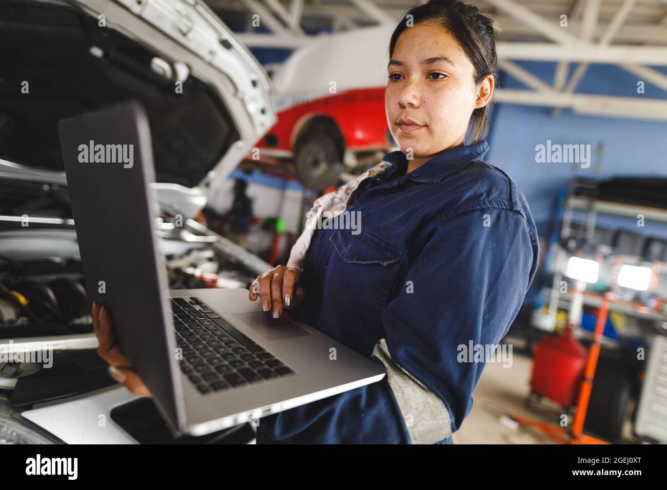 Mixed race female car mechanic wearing overalls, using laptop Stock ...
