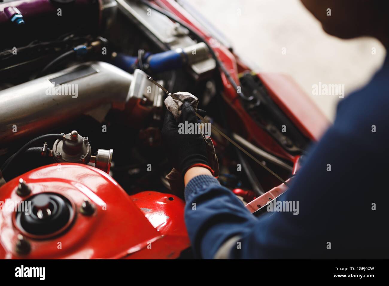 Close up of hands of mixed race female car mechanic wearing overalls ...