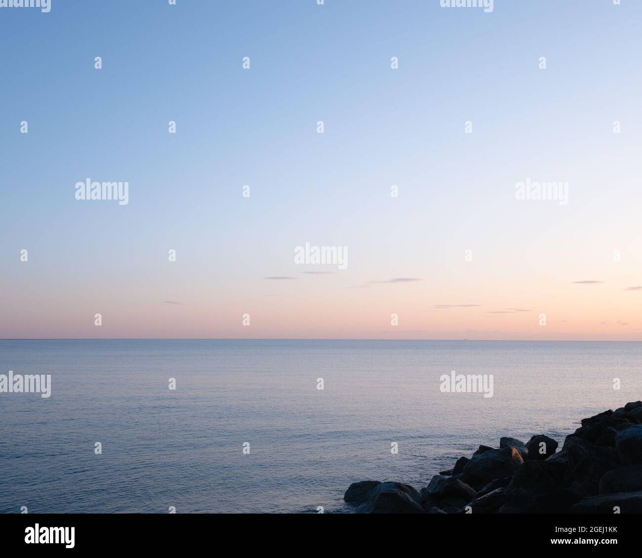 Sunrise over a rock jetty and the Atlantic Ocean. The sky is filled ...